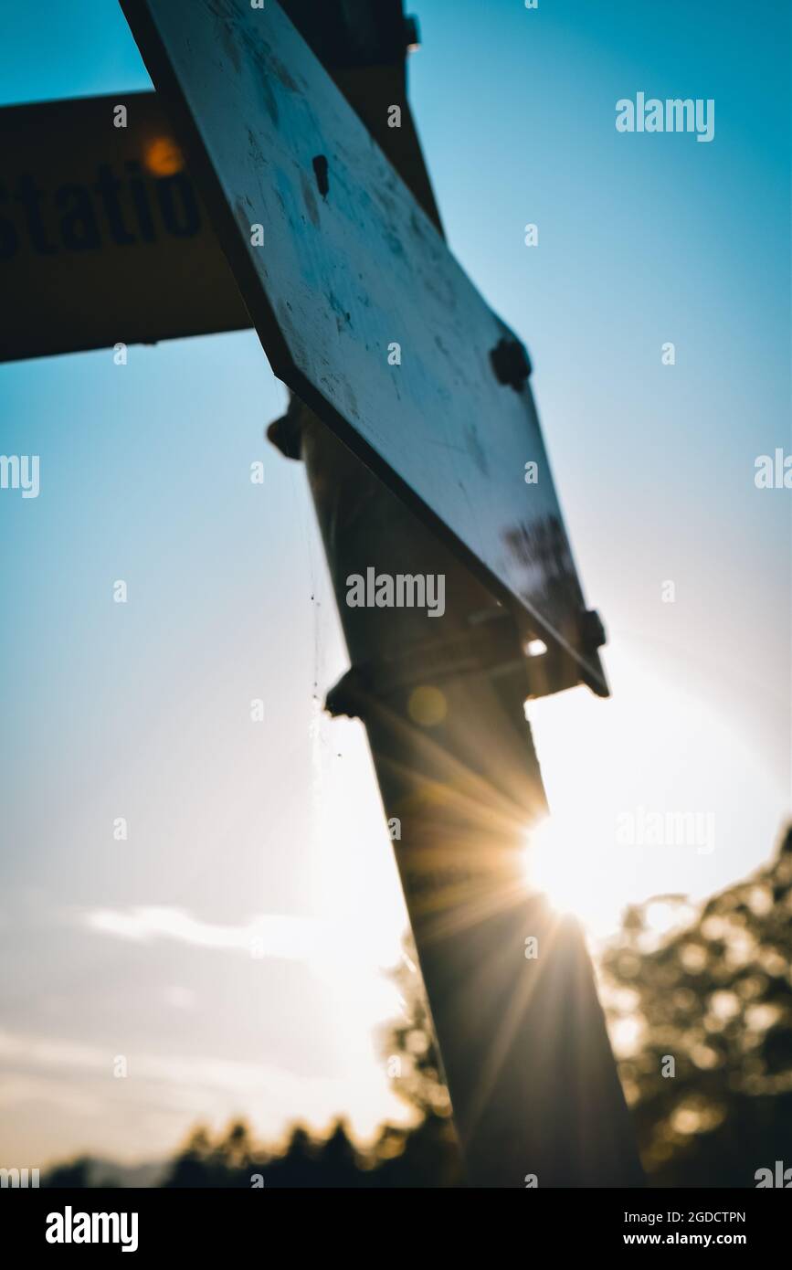 Beautiful sun shining through a road sign post Stock Photo - Alamy