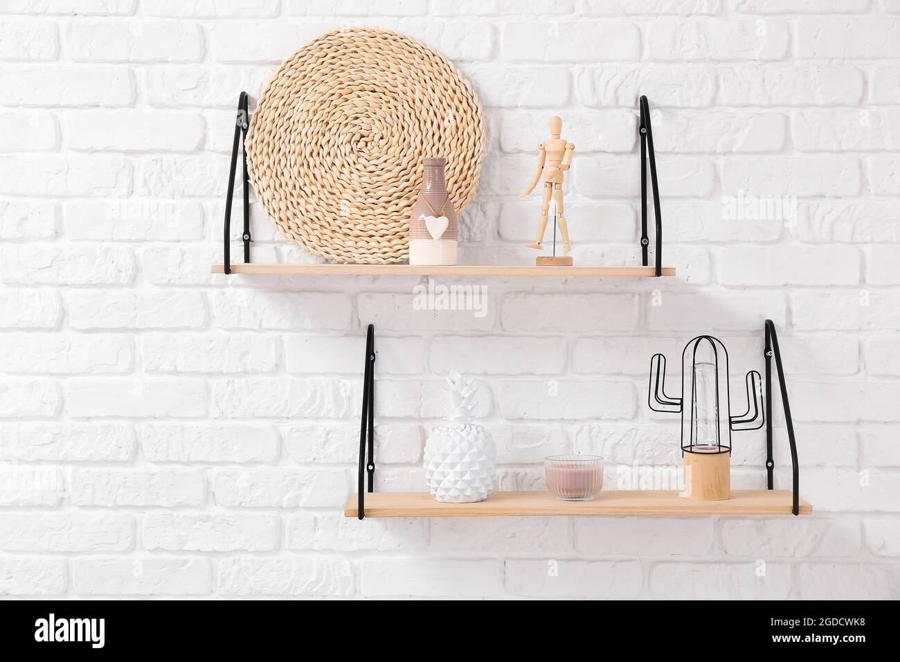 Modern shelves with decor hanging on brick wall Stock Photo - Alamy