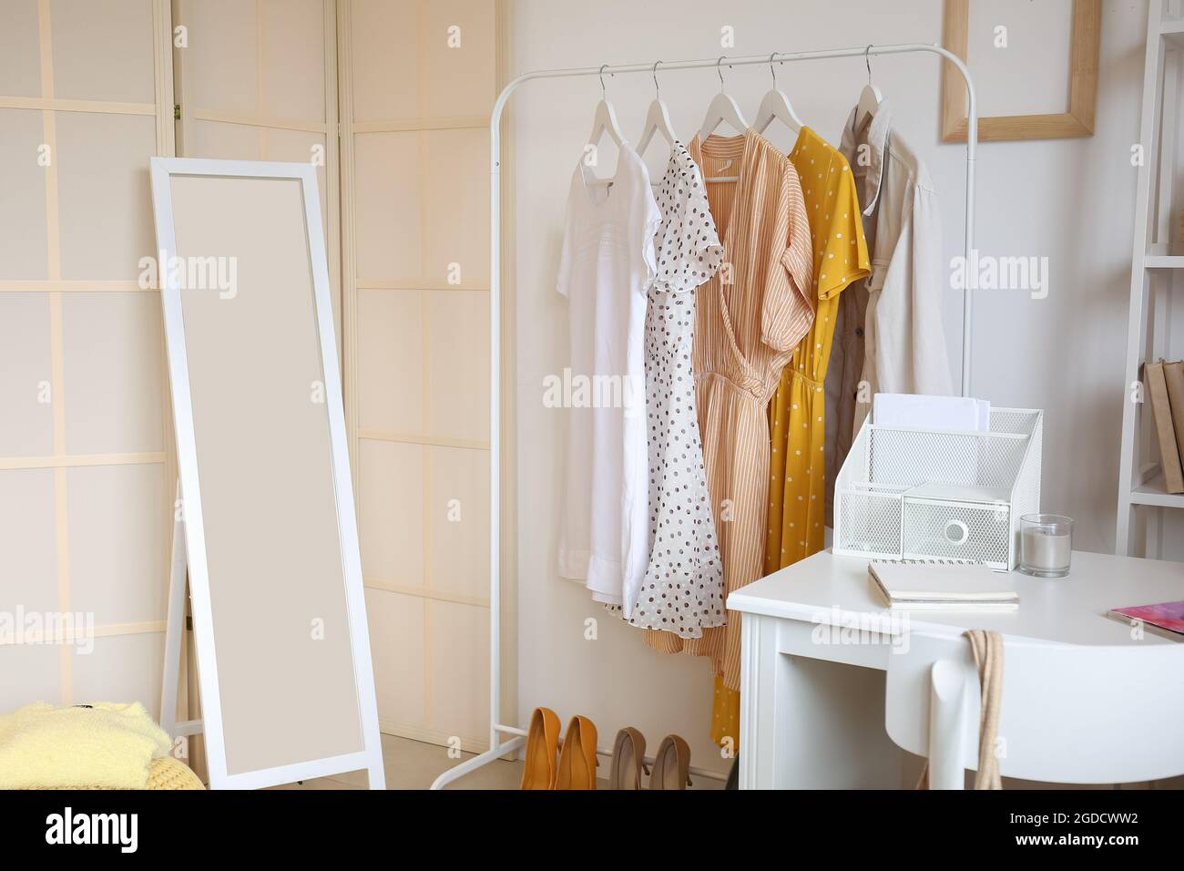 Rack with clothes and mirror in interior of stylish room Stock Photo ...