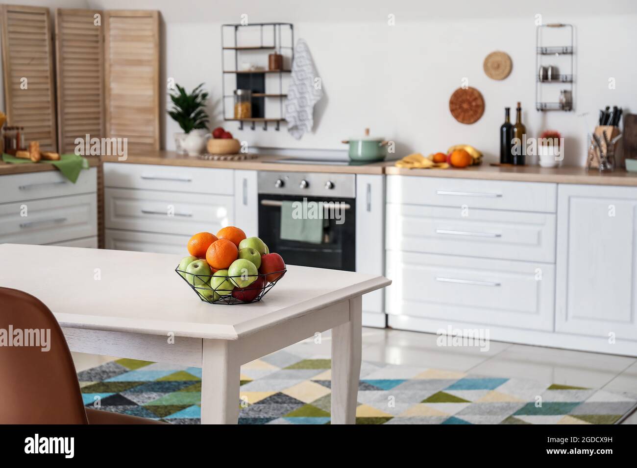 Basket with fresh fruits on dining table in kitchen Stock Photo - Alamy