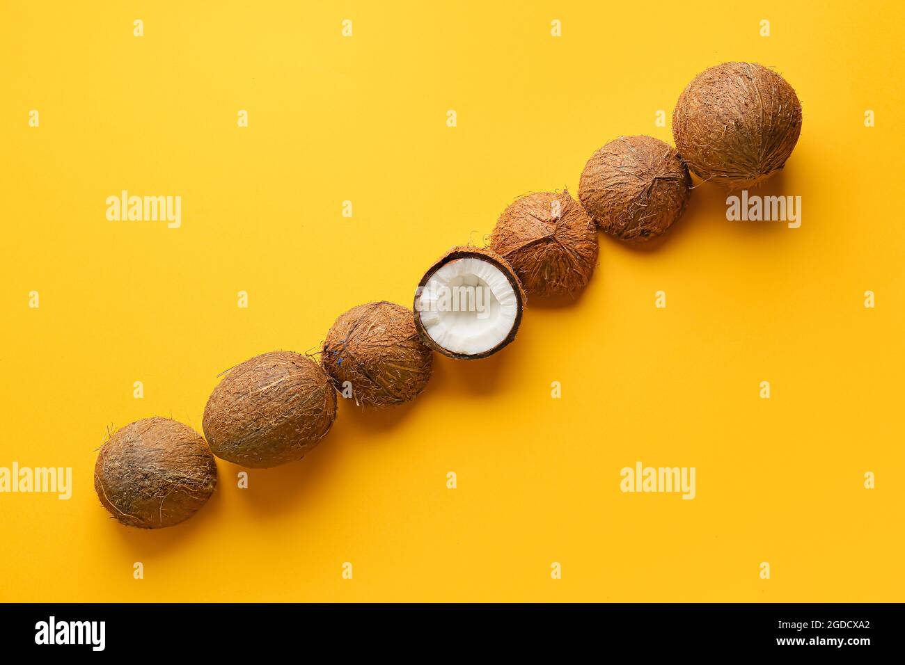 Broken coconut among whole ones on color background. Concept of ...
