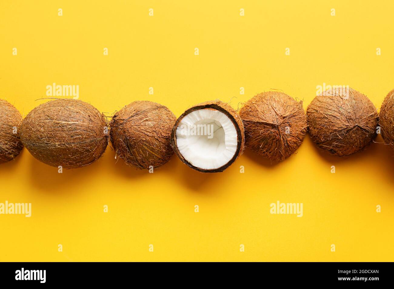 Broken coconut among whole ones on color background. Concept of ...