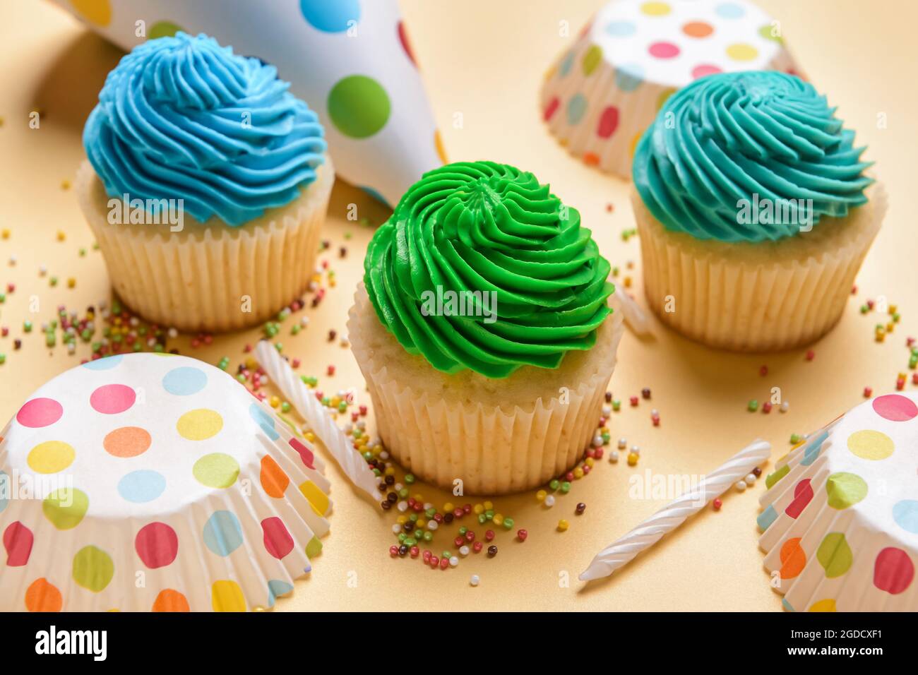 Composition with tasty Birthday cupcakes, party hat and candles on ...