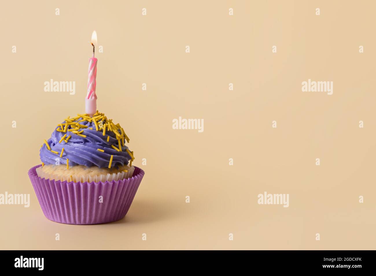 Tasty Birthday cupcake with burning candle on color background Stock ...