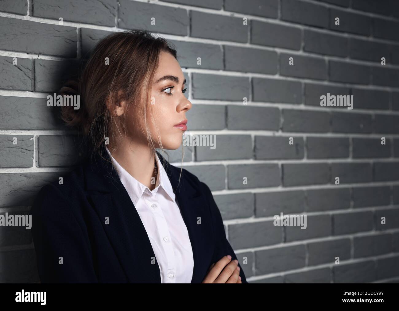 Young depressed businesswoman near brick wall Stock Photo - Alamy