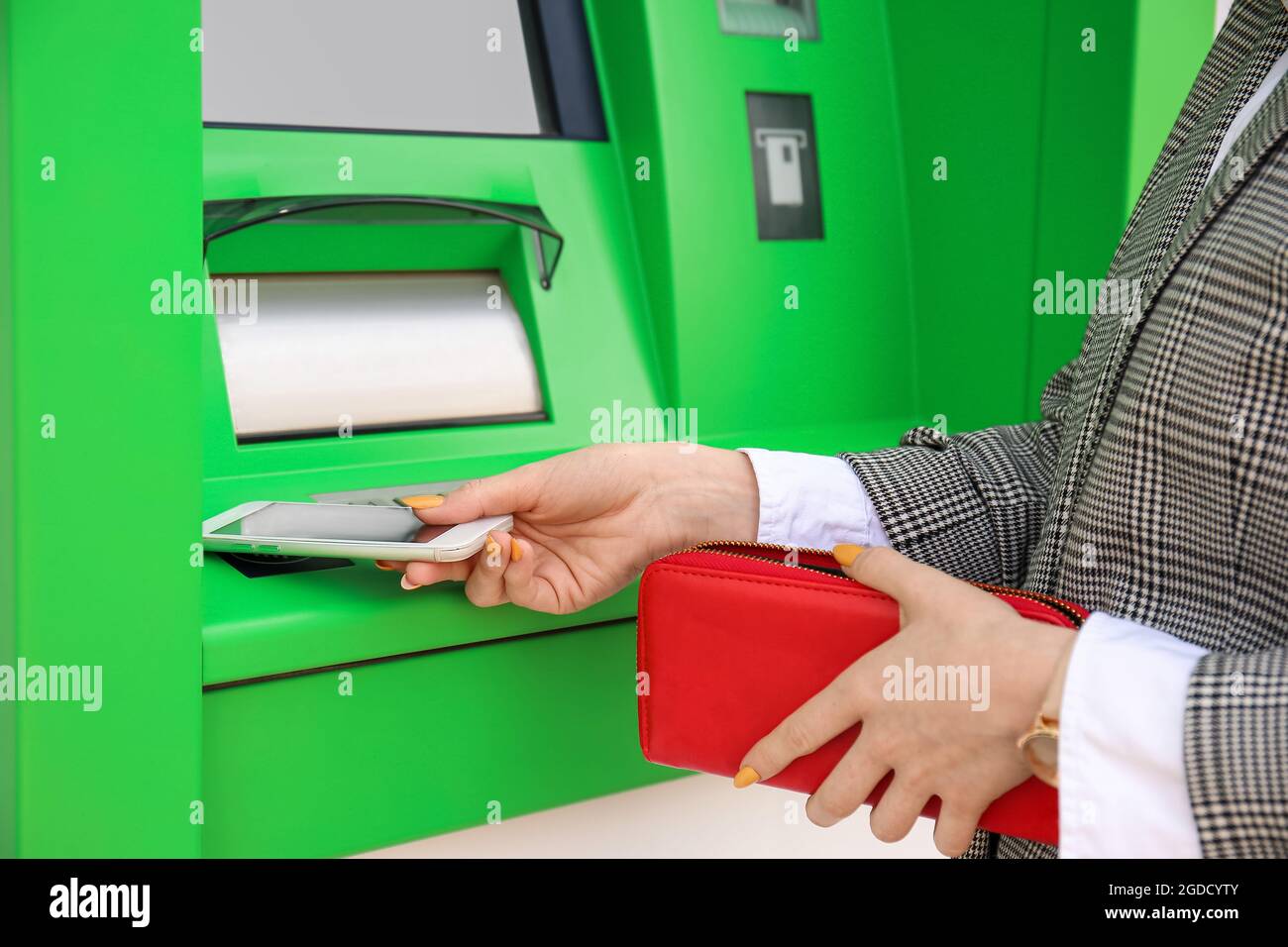 Withdrawing money at the atm with phone hi-res stock photography and ...