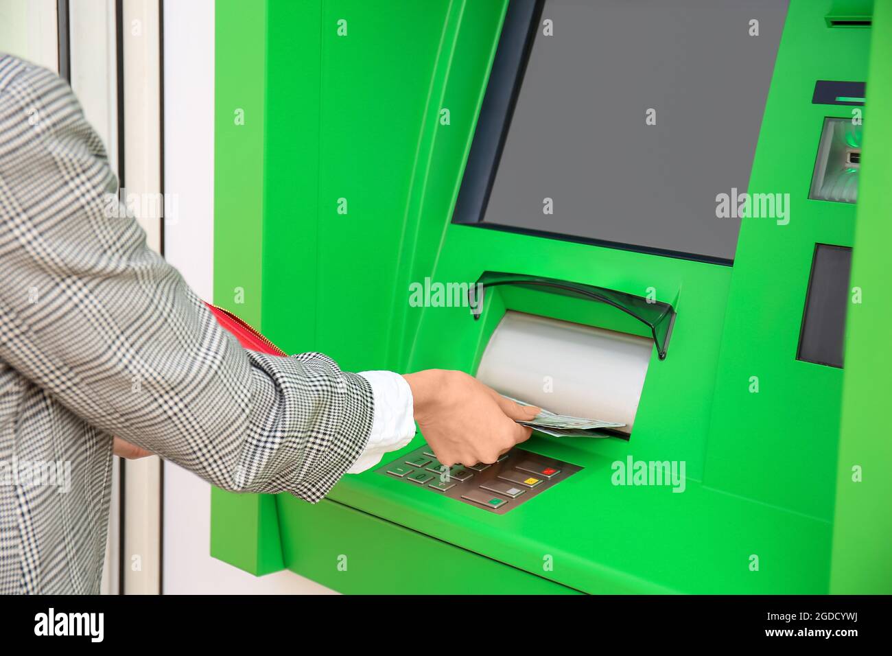 Woman withdrawing money from ATM Stock Photo - Alamy