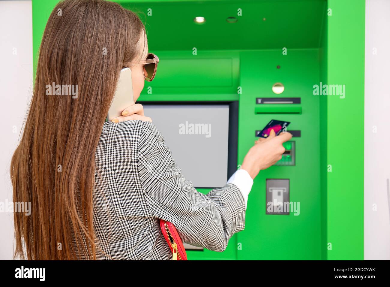 Withdrawing money at the atm with phone hi-res stock photography and ...