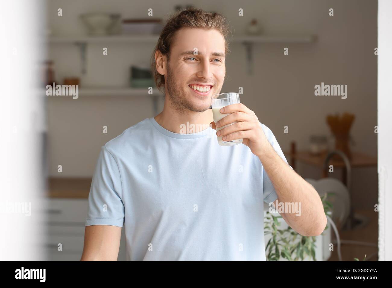 Young man drinking fresh milk at home Stock Photo - Alamy