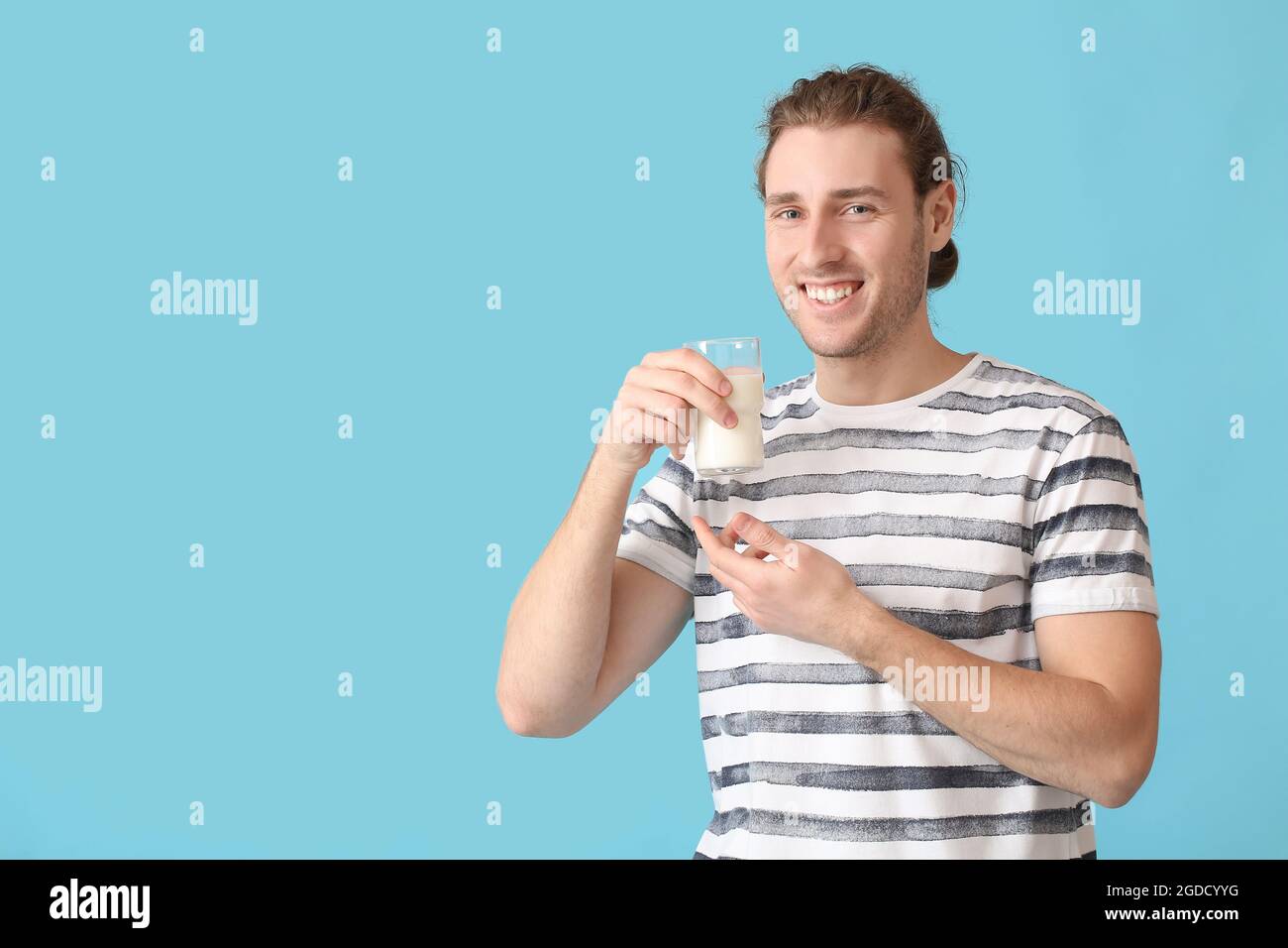 Young man with glass of milk on color background Stock Photo - Alamy