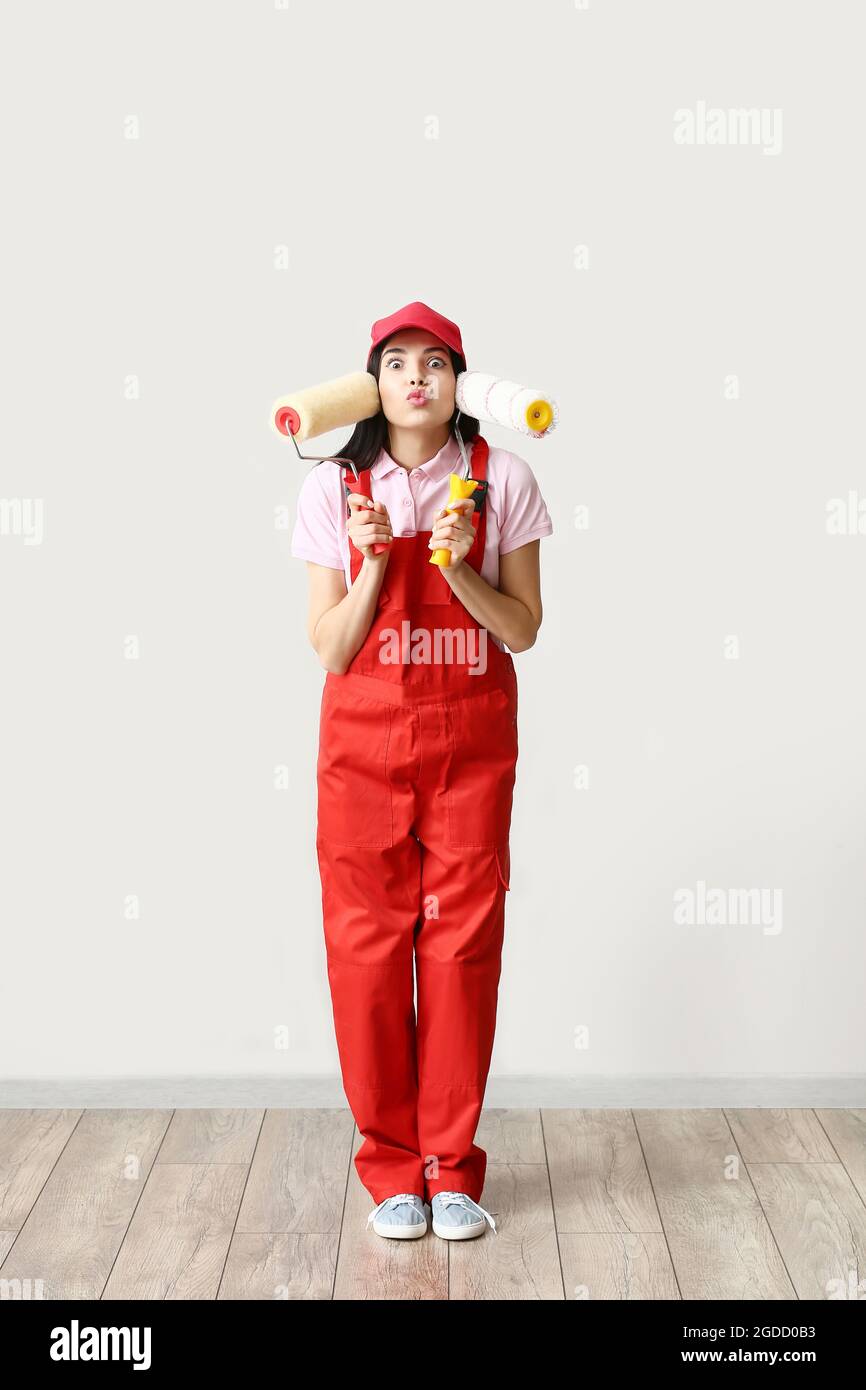 Funny female decorator with paint rollers near light wall Stock Photo ...