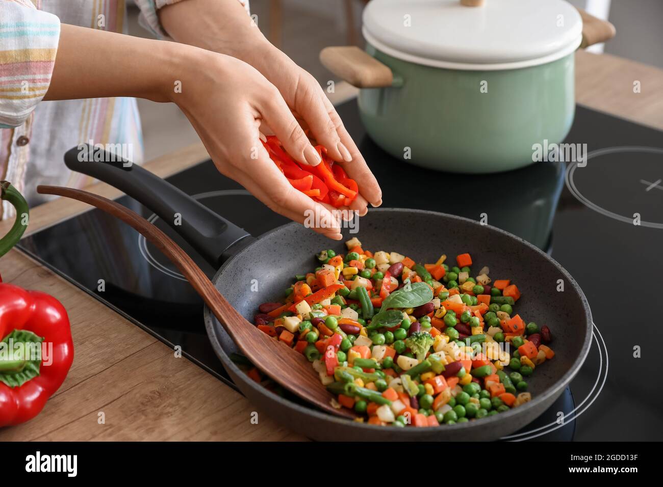 Young woman adding frying hi-res stock photography and images - Alamy
