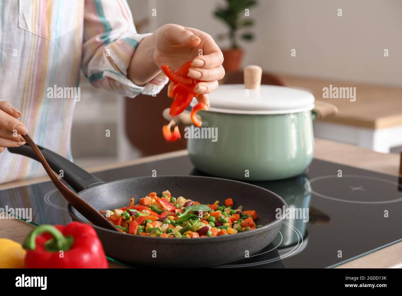Woman frying vegetables in hi-res stock photography and images - Alamy
