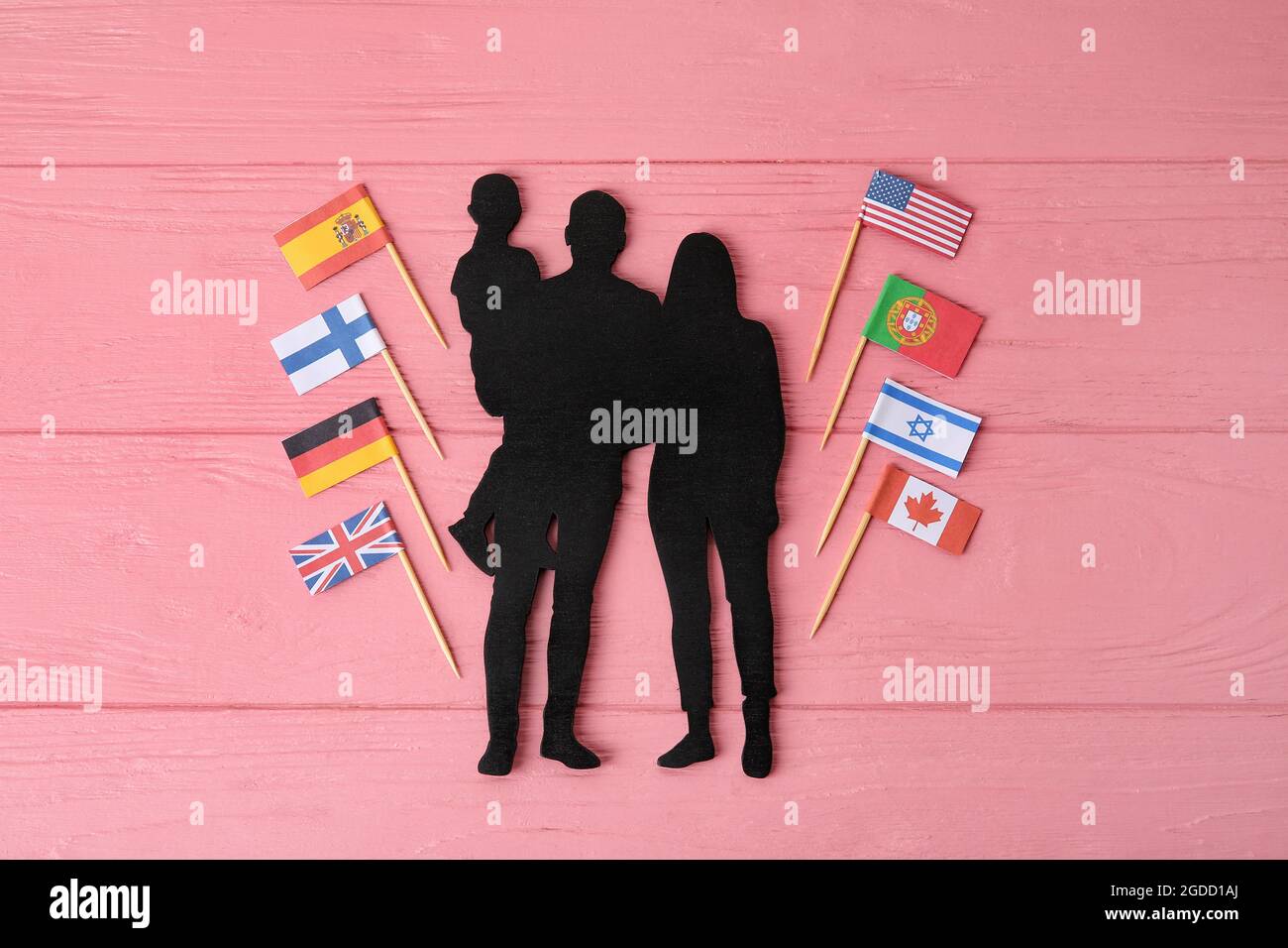 Figure of family and flags of different countries on color wooden ...