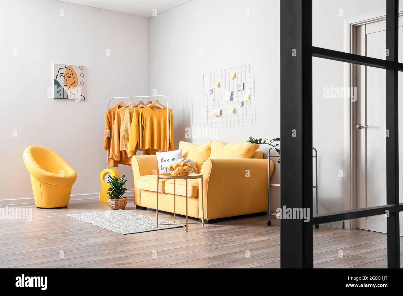 Interior of stylish living room with clothes Stock Photo - Alamy