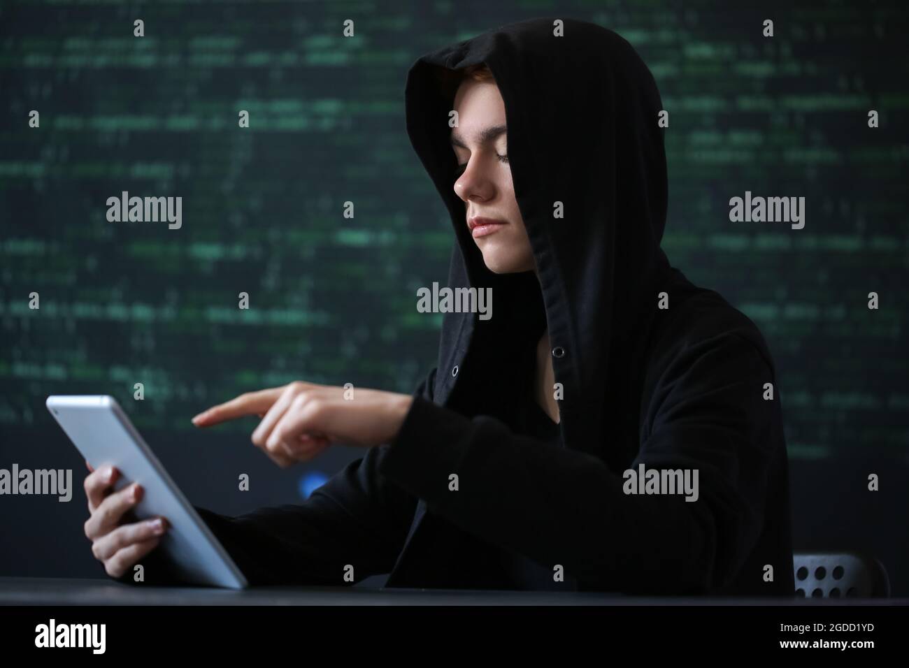 Hacker with tablet computer on dark background Stock Photo - Alamy