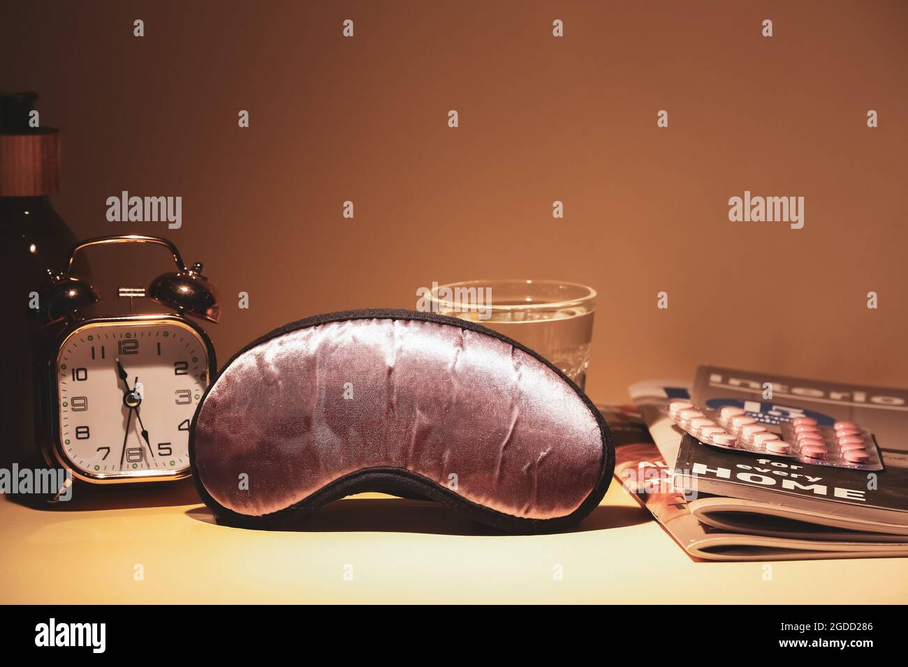 Sleeping mask with pills and magazines on dark background Stock Photo ...