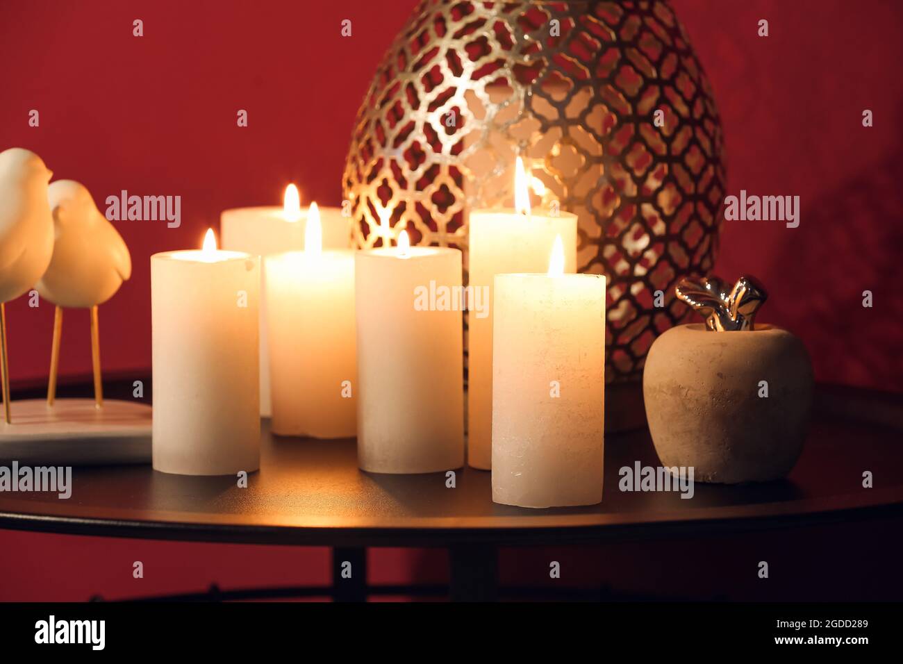 Burning candles on table in dark room Stock Photo - Alamy
