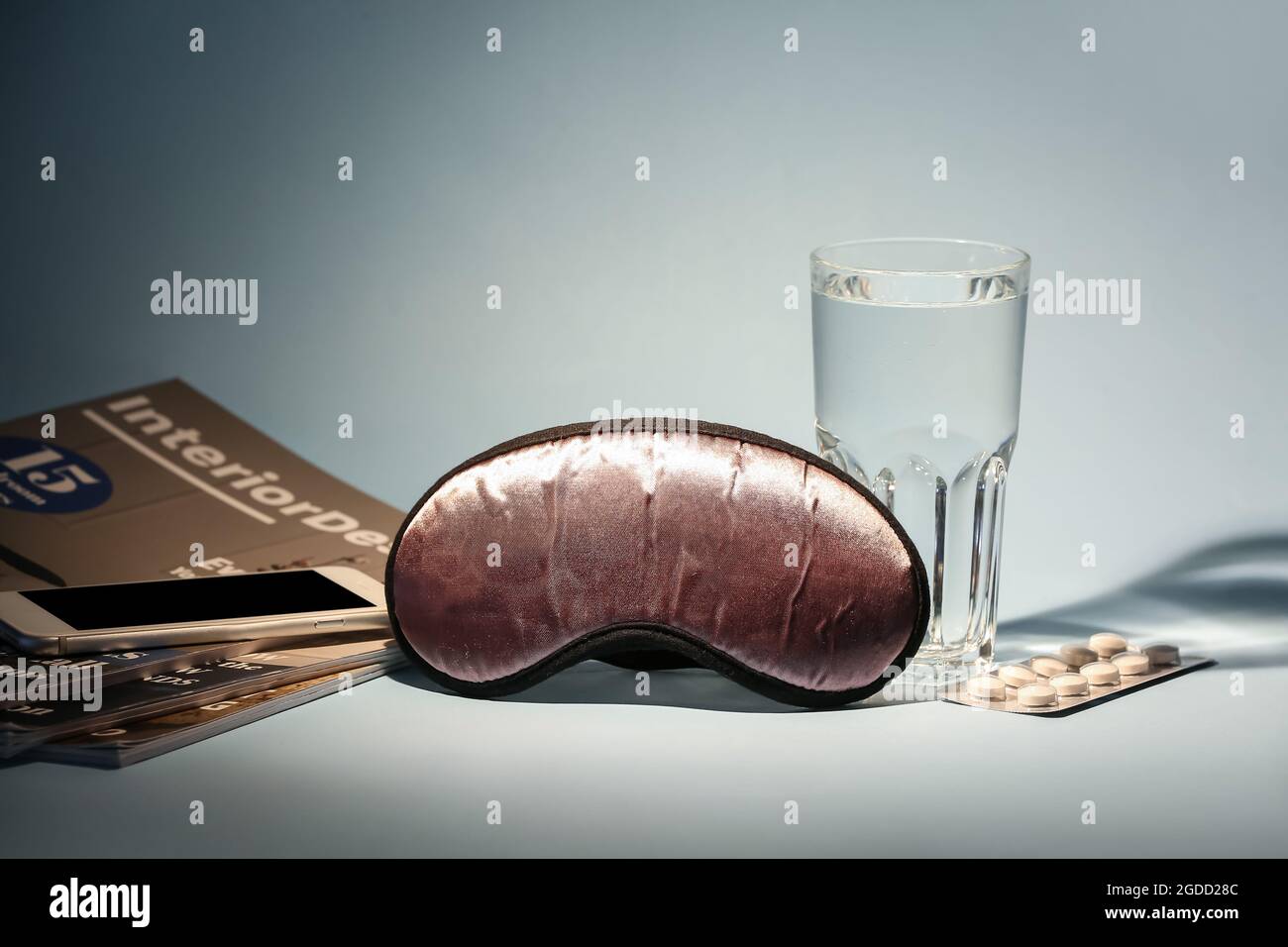 Sleeping mask with pills and glass of water on color background Stock ...