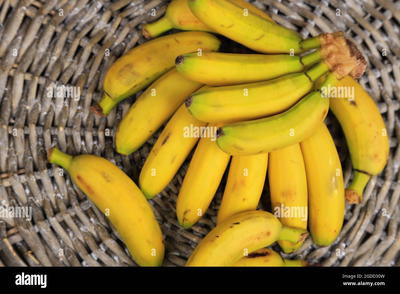 Bunch of mini bananas on wicker mat background Stock Photo - Alamy
