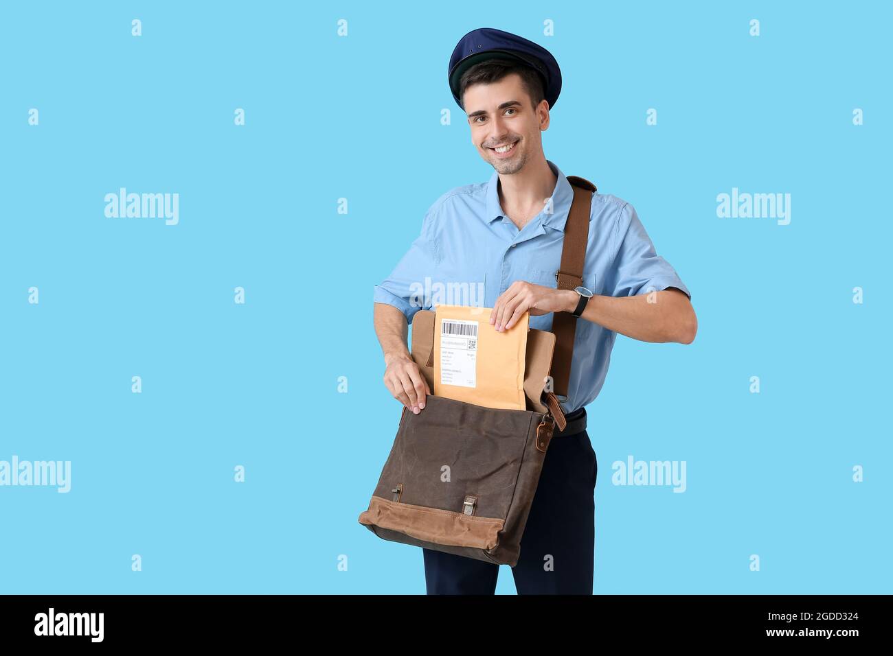 Handsome young postman on color background Stock Photo - Alamy