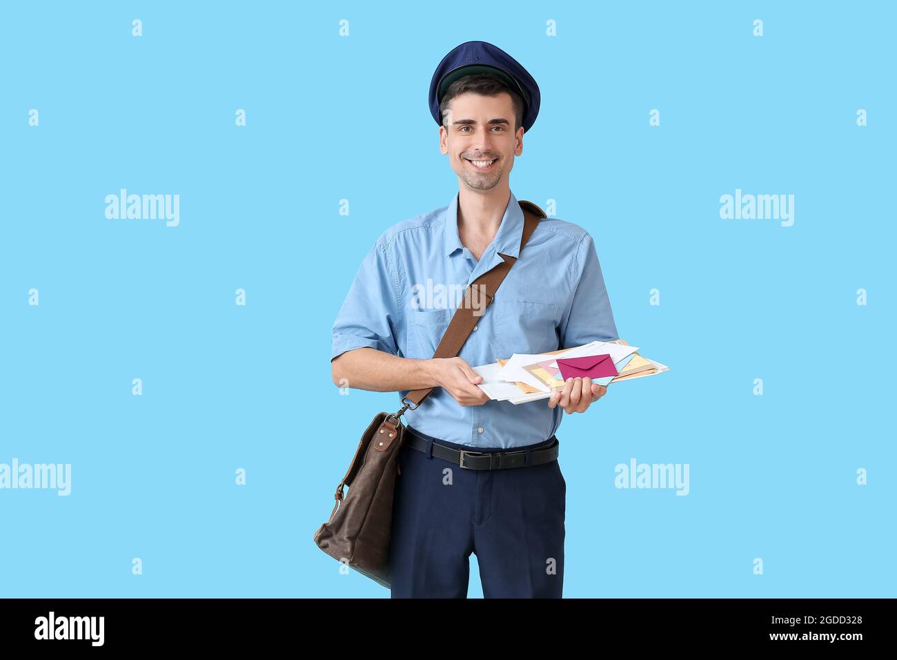 Handsome young postman with letters on color background Stock Photo - Alamy