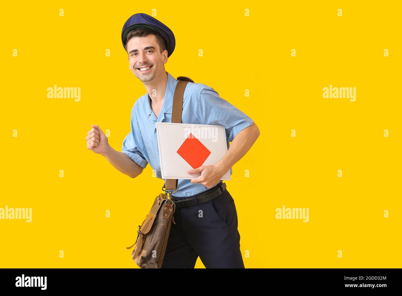 Handsome young postman with letter on color background Stock Photo - Alamy
