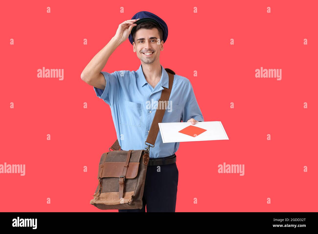 Handsome young postman with letter on color background Stock Photo - Alamy