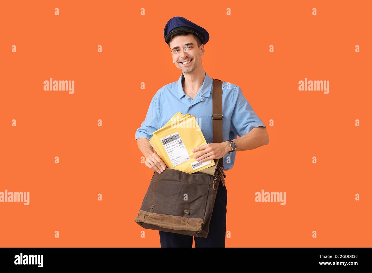 Handsome young postman on color background Stock Photo - Alamy