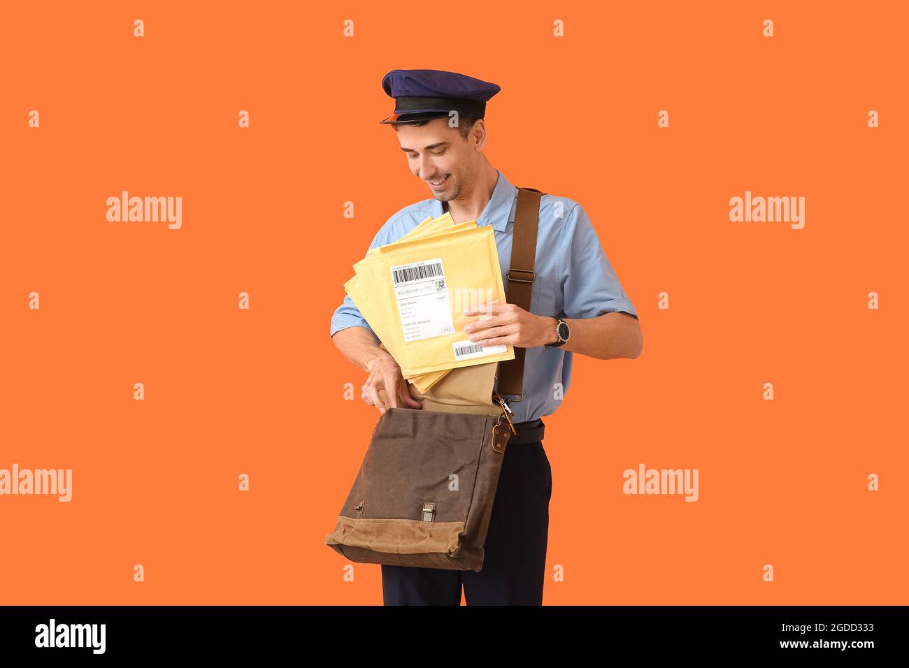 Handsome young postman on color background Stock Photo - Alamy