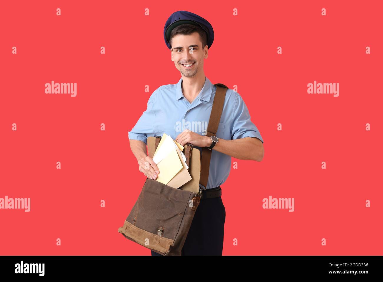 Handsome young postman on color background Stock Photo - Alamy