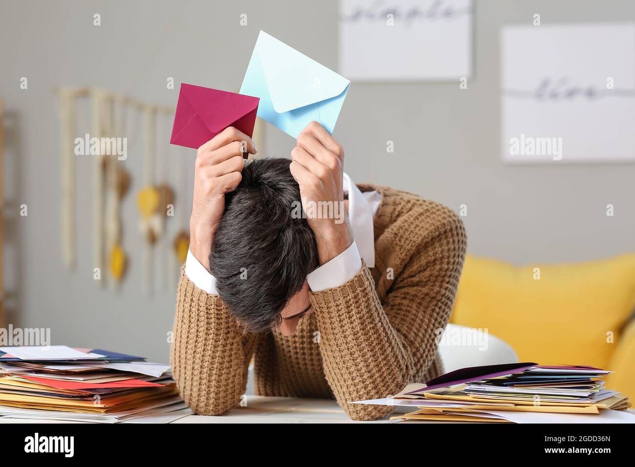 Stressed young man with letters at home Stock Photo - Alamy