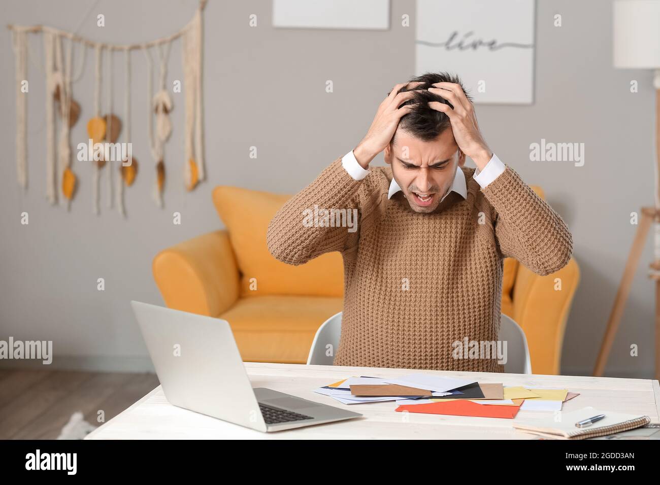 Stressed young man with letters at home Stock Photo - Alamy