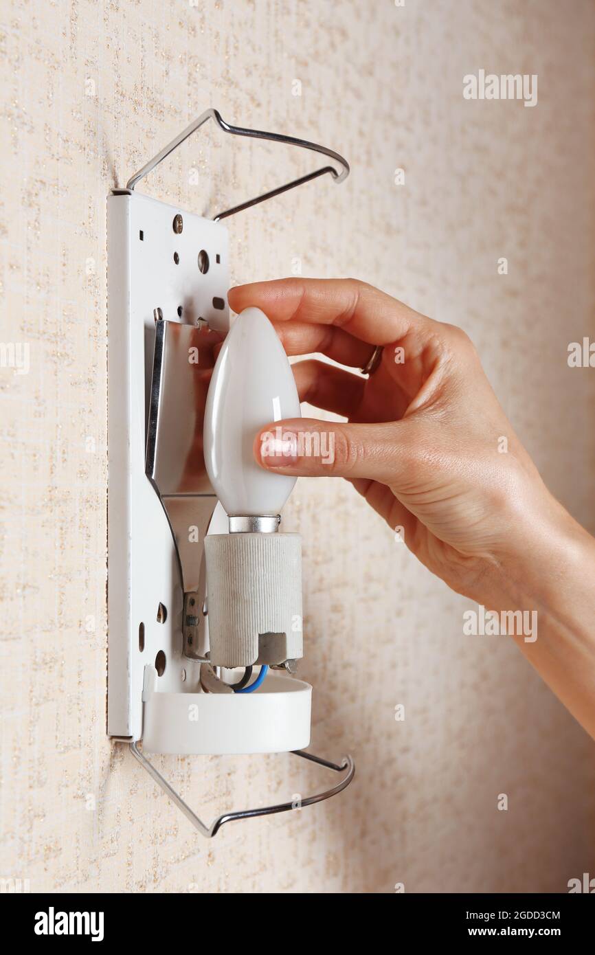 Hand changing light bulb at home Stock Photo - Alamy