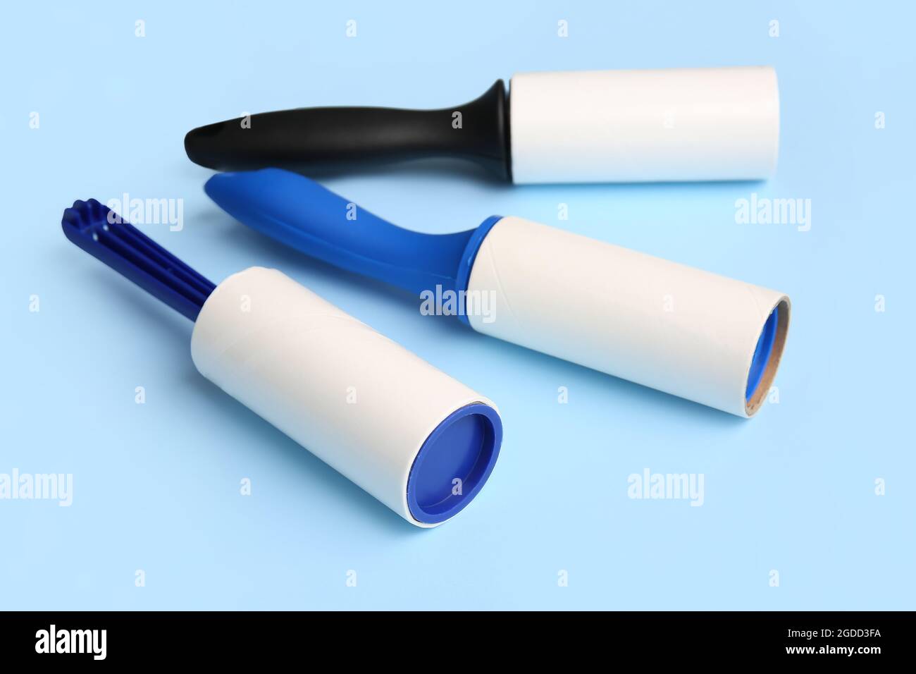 Different lint rollers on color background Stock Photo - Alamy