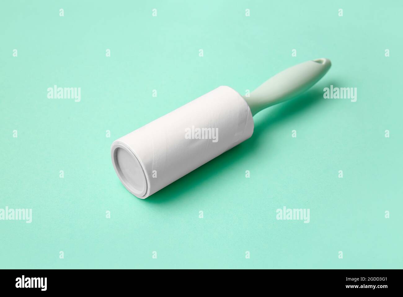 Lint roller on color background Stock Photo - Alamy