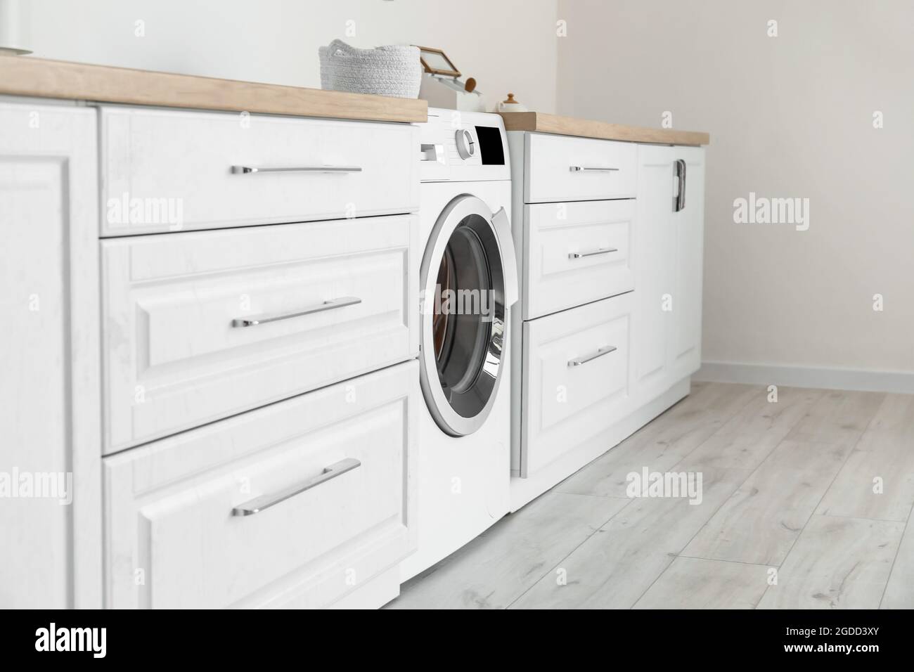 Modern washing machine with laundry in kitchen Stock Photo - Alamy