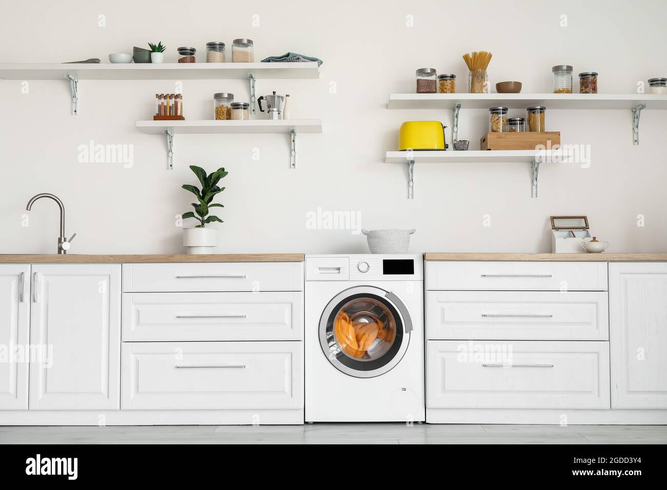 Interior of kitchen with modern washing machine Stock Photo - Alamy