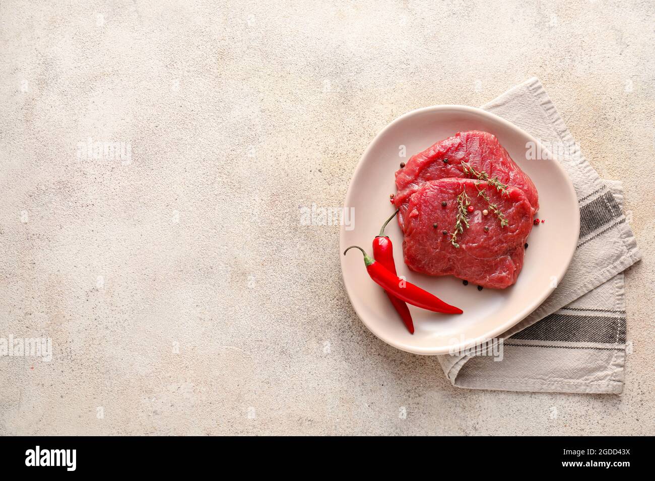 Plate with raw beef meat on light background Stock Photo - Alamy