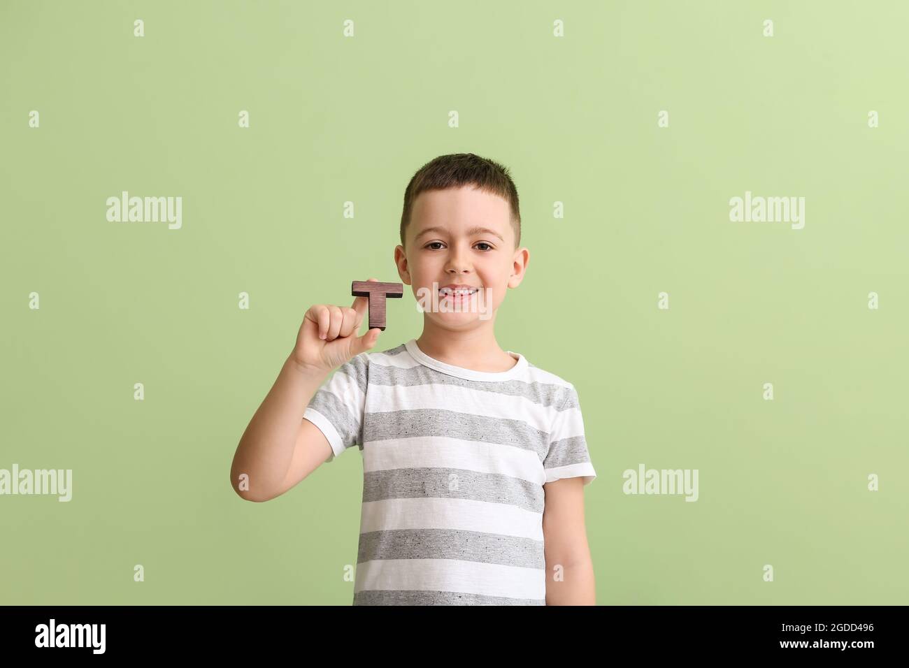 Little boy with letter T on color background Stock Photo - Alamy