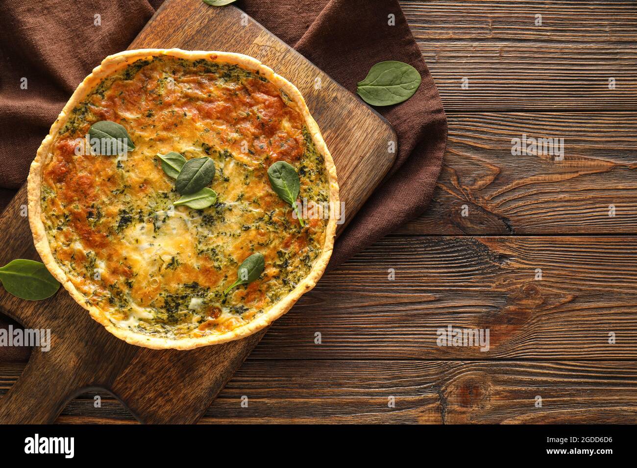 Board with tasty spinach tart on wooden background Stock Photo - Alamy