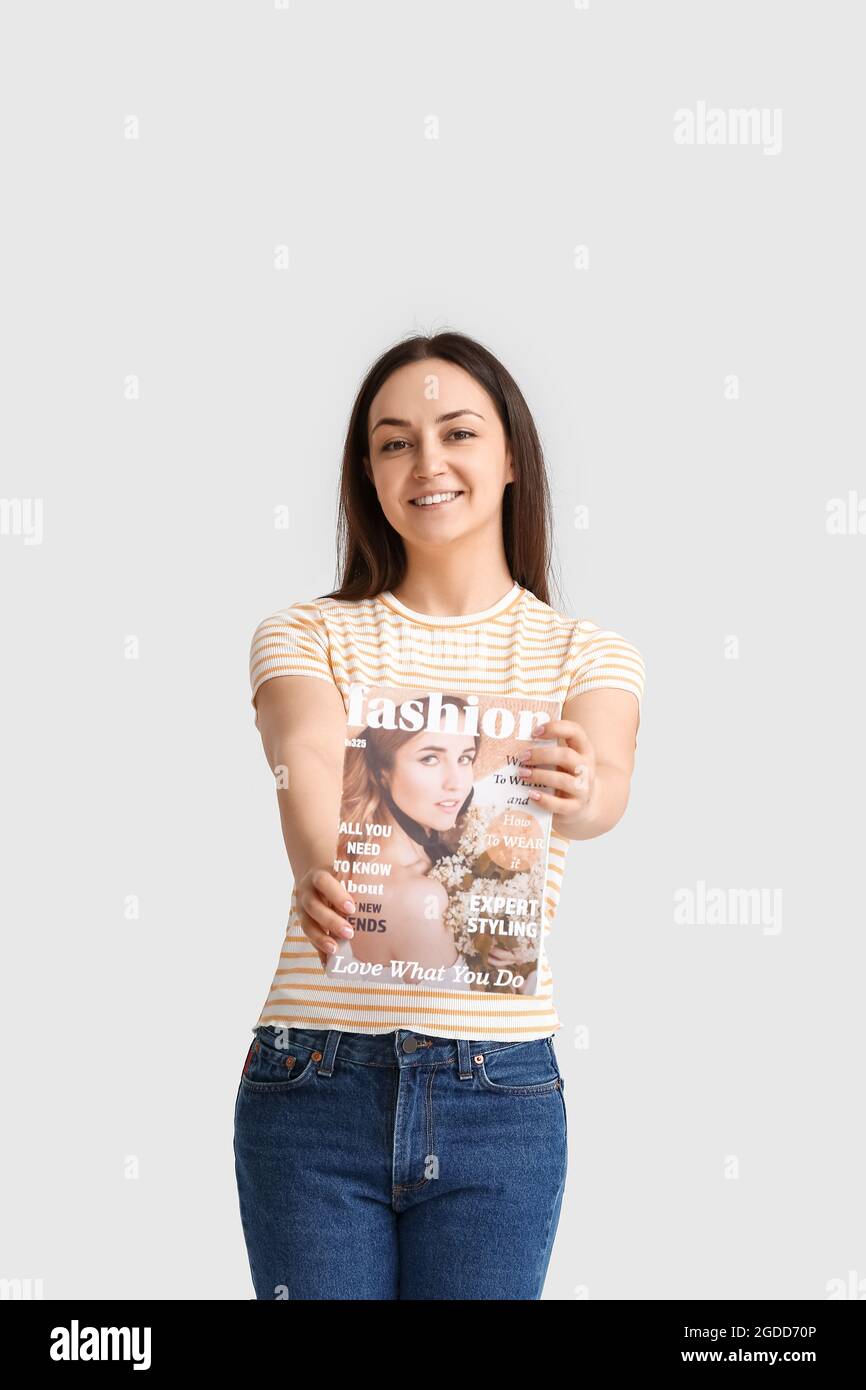 Beautiful young woman with magazine on grey background Stock Photo - Alamy