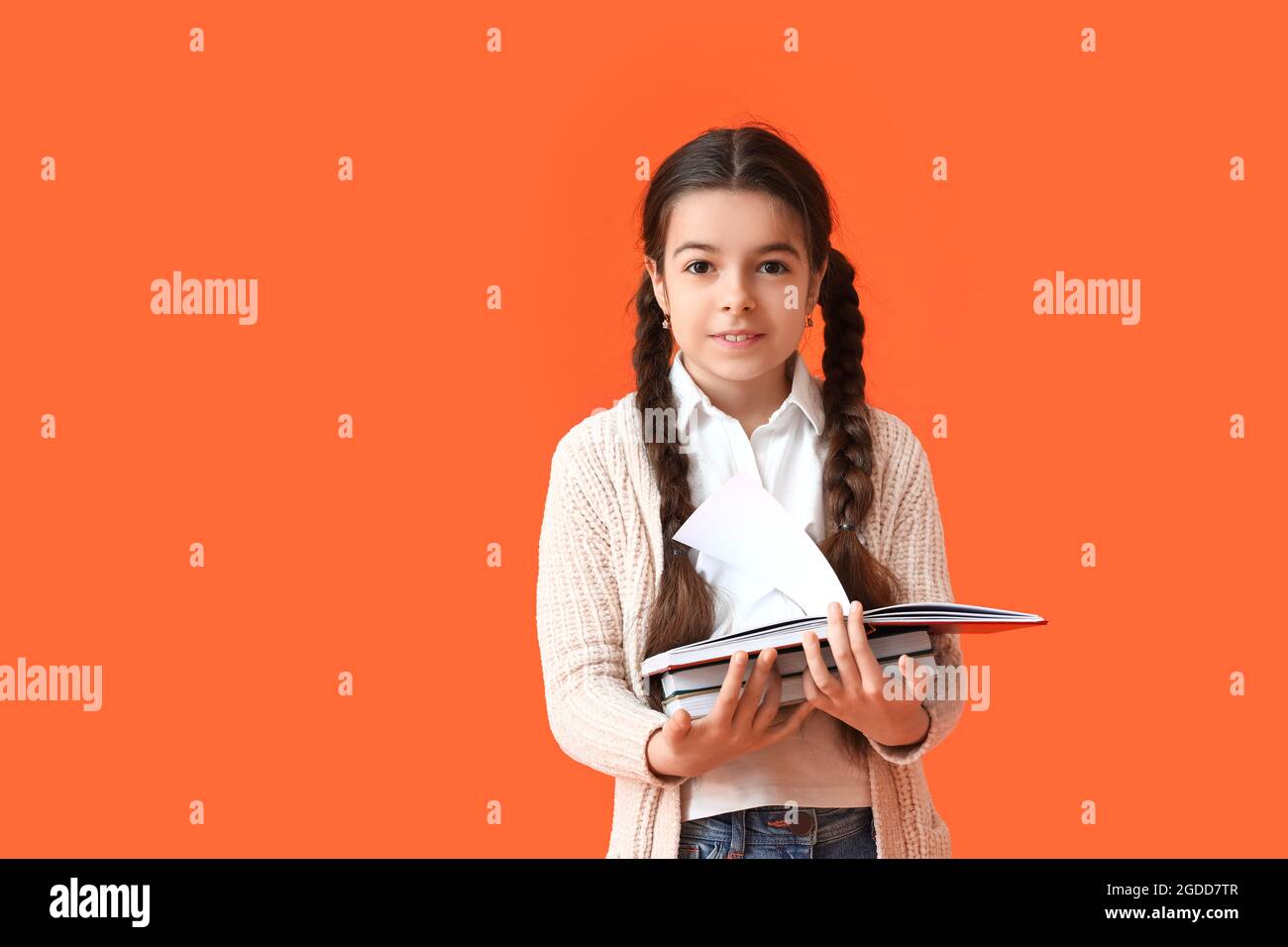 Cute little school girl with books on color background Stock Photo - Alamy