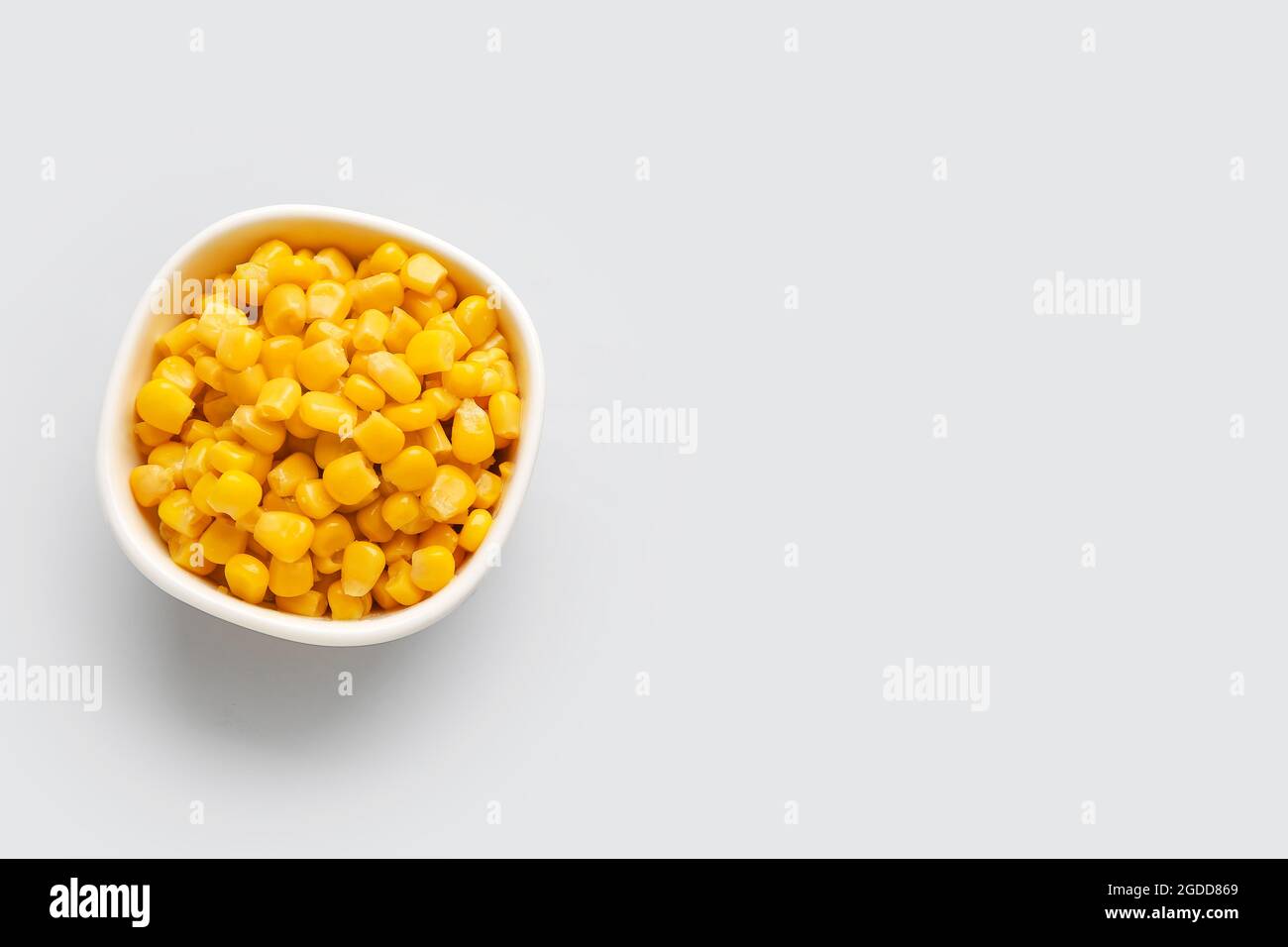 Bowl of corn kernels on white background Stock Photo - Alamy