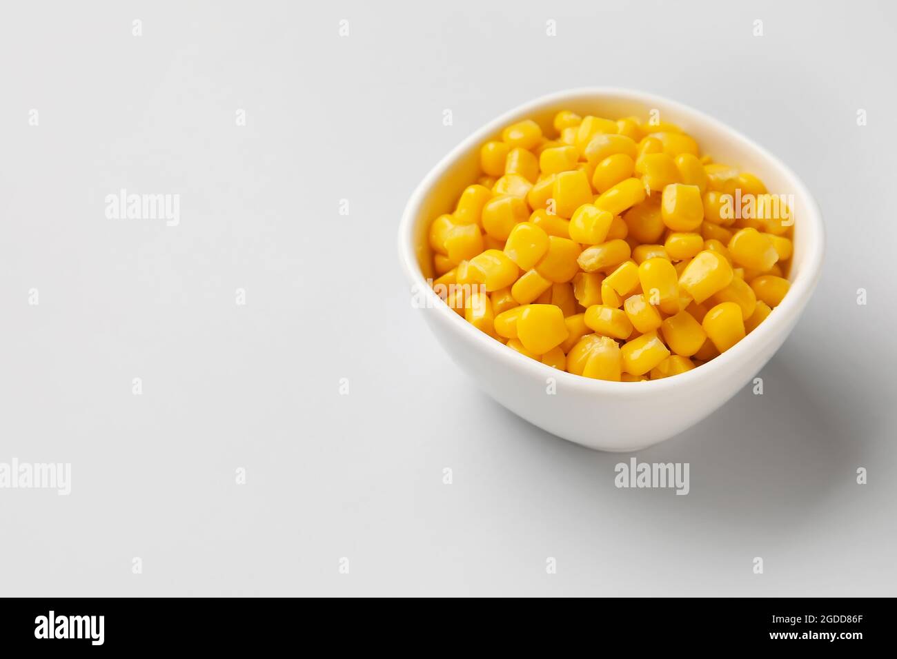 Bowl of corn kernels on white background Stock Photo - Alamy