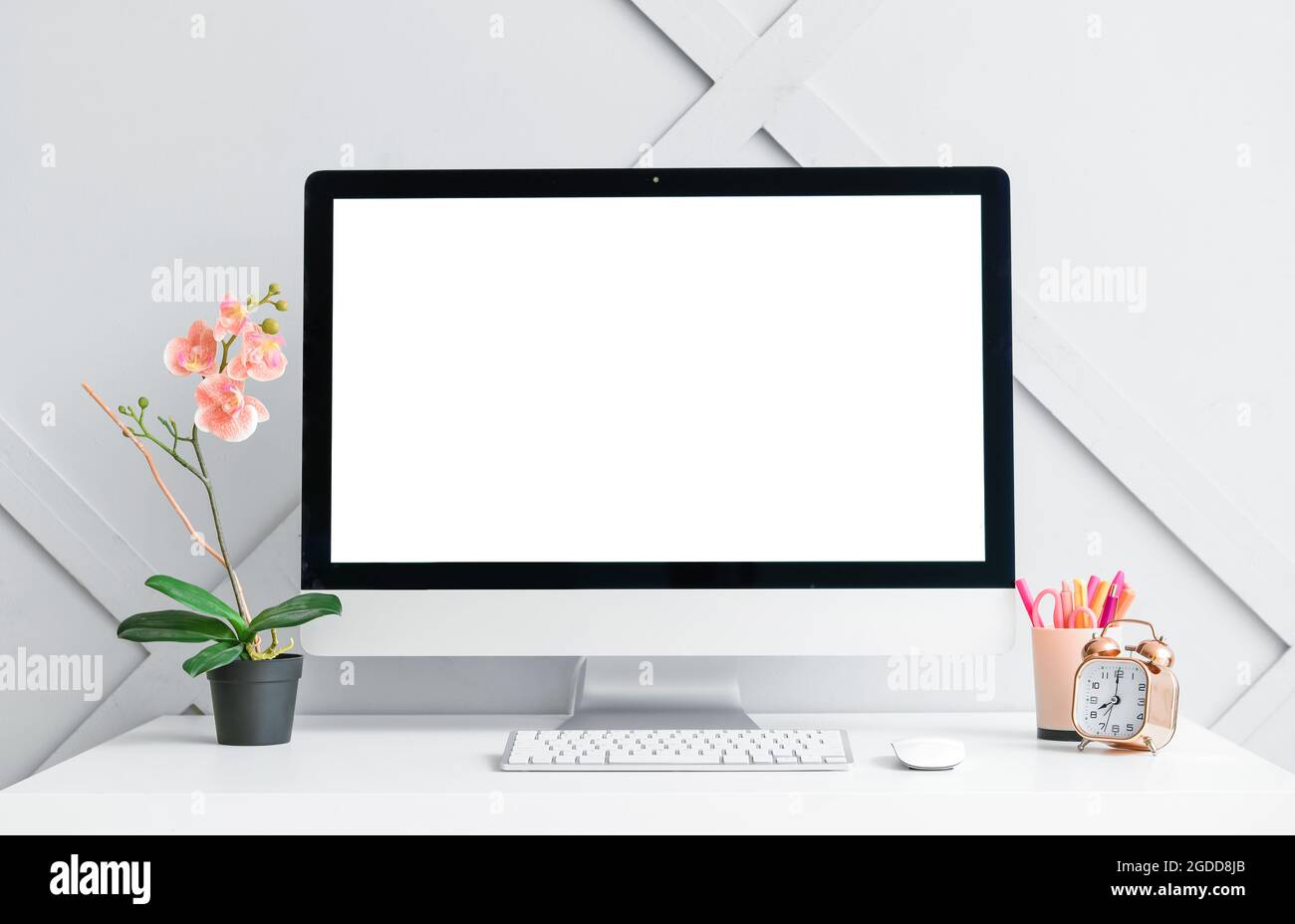 Workplace with modern PC monitor on table near light wall Stock Photo ...
