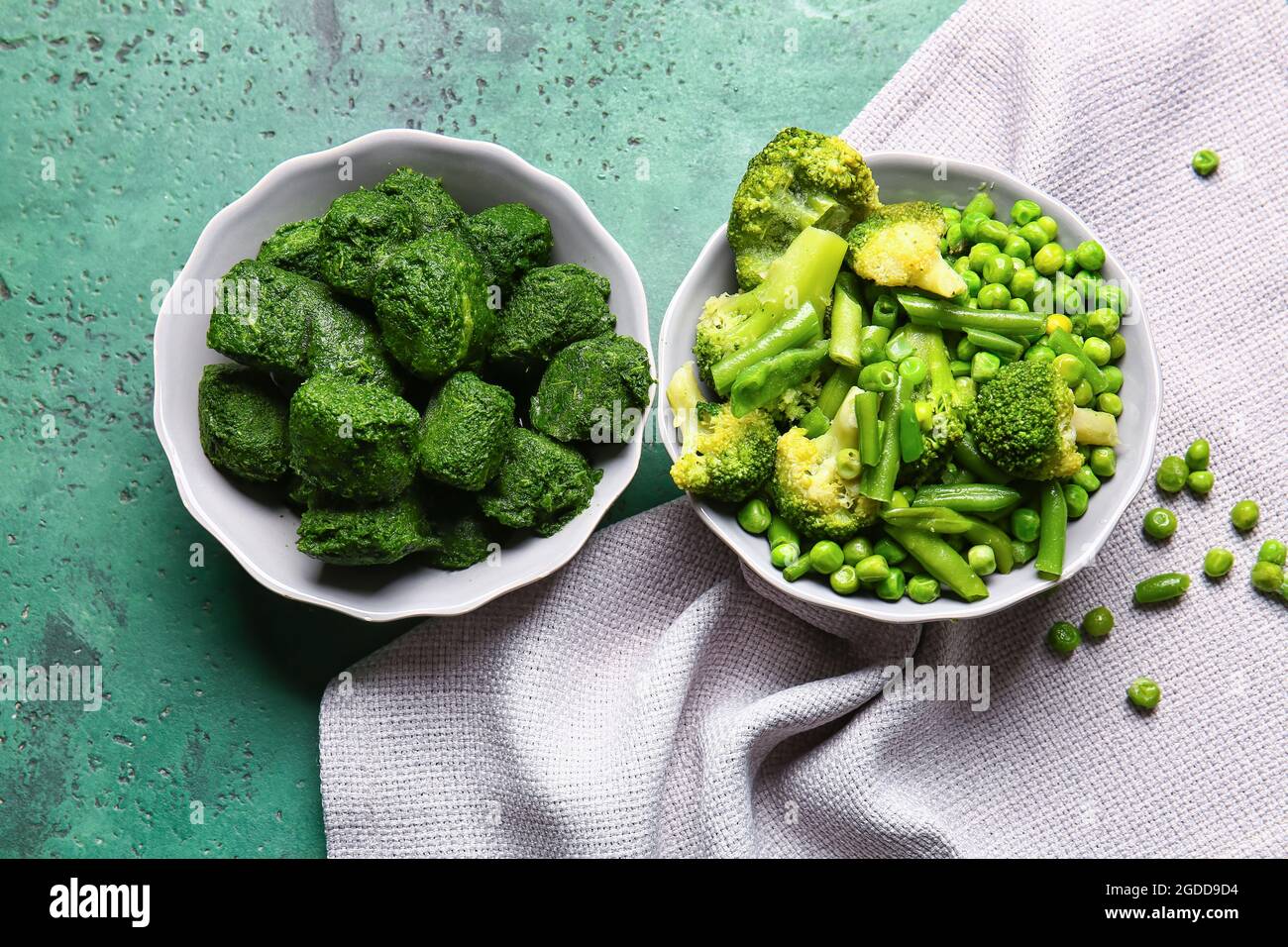 Bowls with frozen green vegetables on color background Stock Photo - Alamy