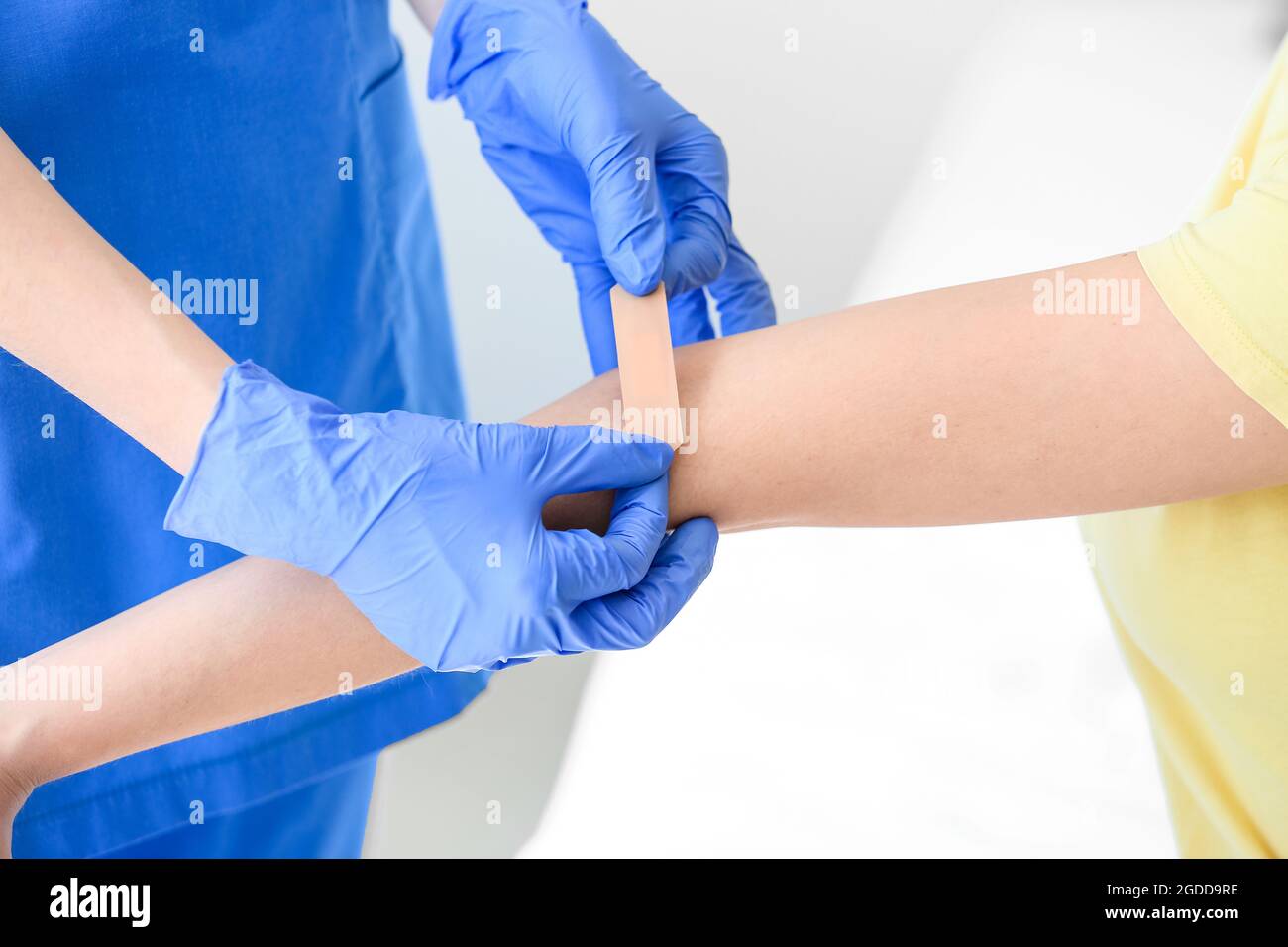 Nurse applying medical patch on young woman's arm in clinic Stock Photo ...