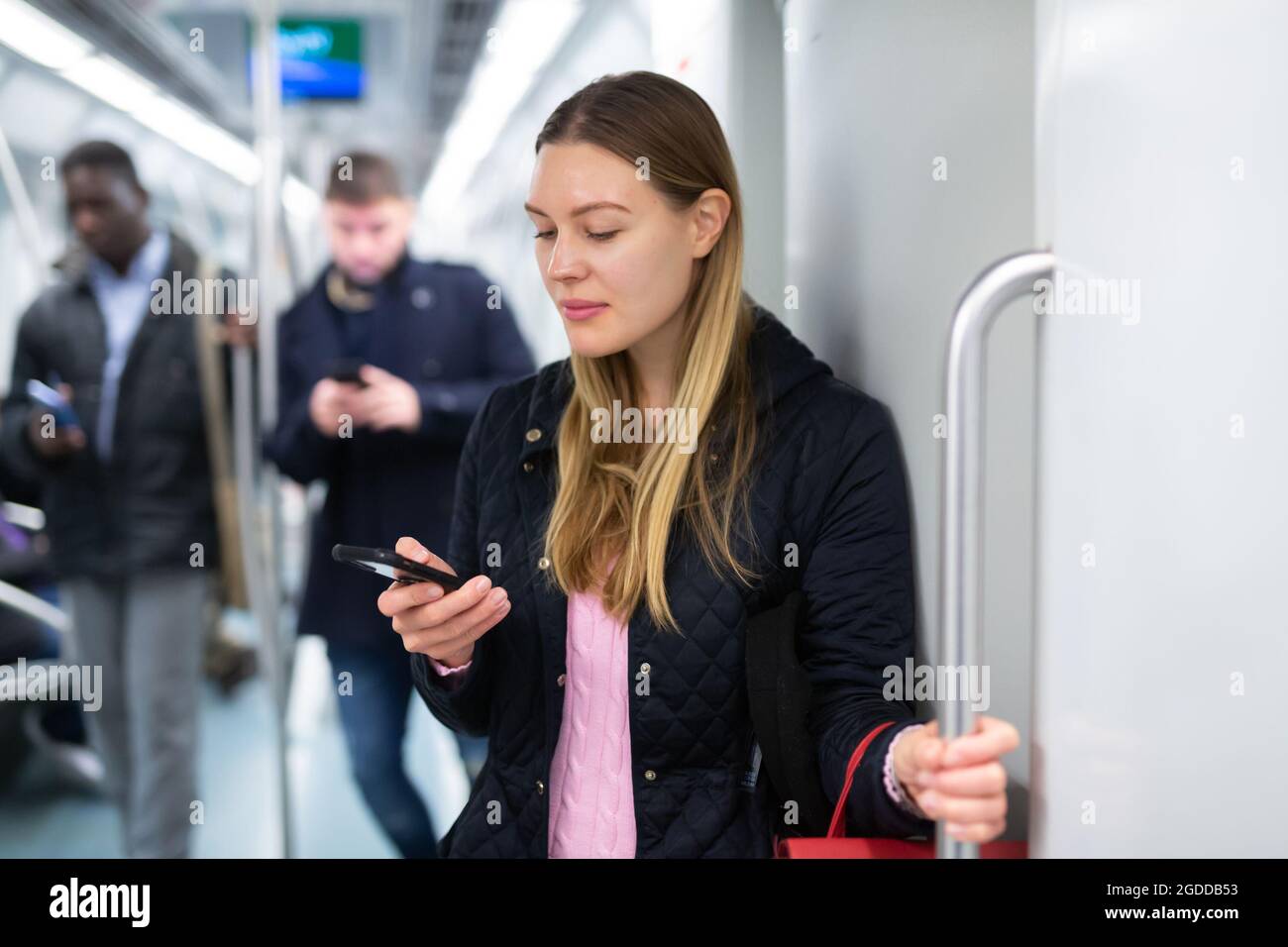 Girl using mobile phone in metro car Stock Photo - Alamy