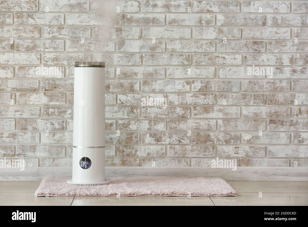 Modern humidifier near brick wall Stock Photo - Alamy